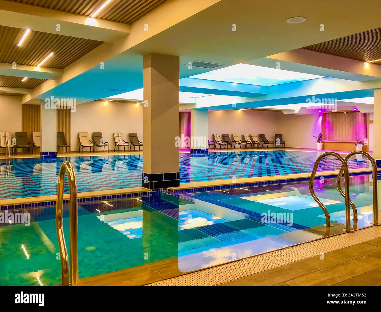 Swimming pool and relaxation area in modern spa center. Indoor swimming ...