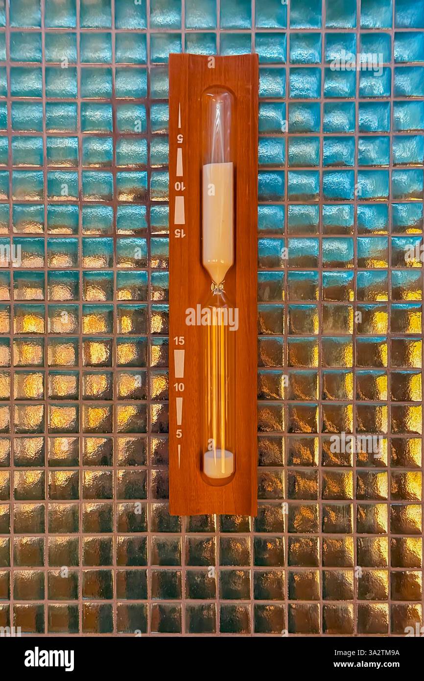Wooden sand timer for sauna mounted on a glass mosaic wall. Traditional ...