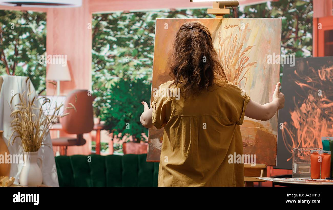 Skilled woman painting an artwork with colorful paints mixed on a ...