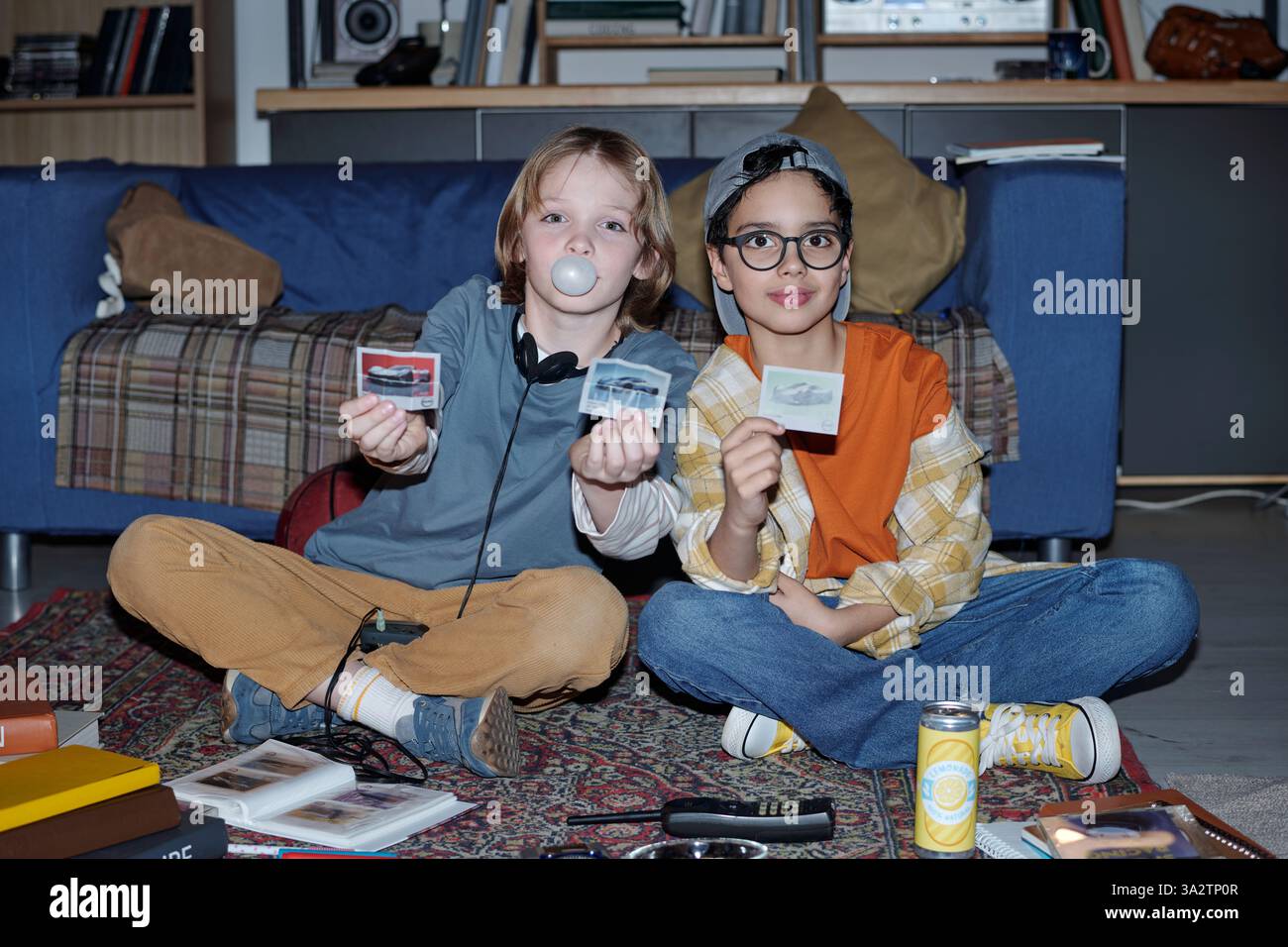 Two children holding collectible cards and looking engaged in activity ...