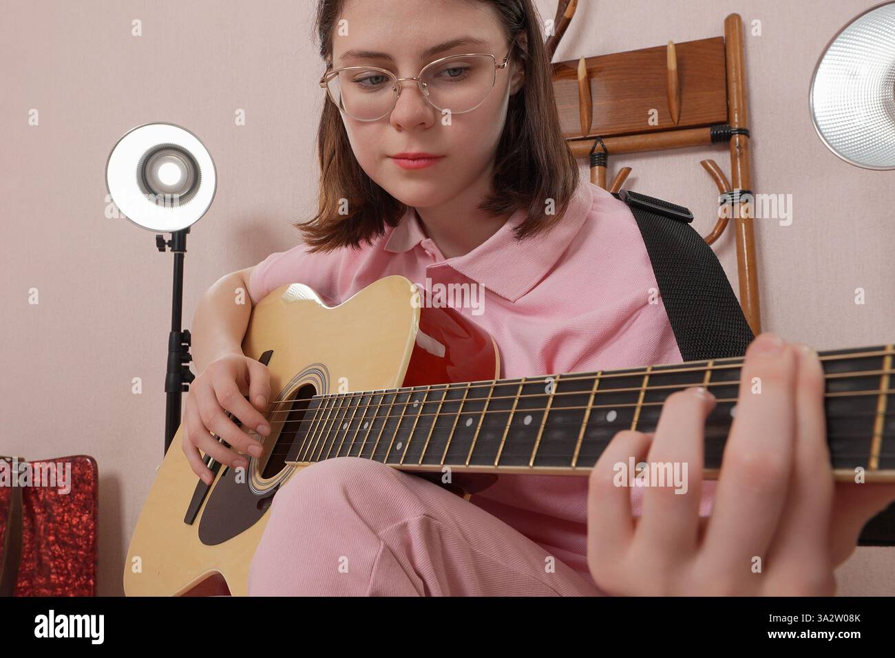 Young woman playing classical six string acoustic guitar and plucking ...