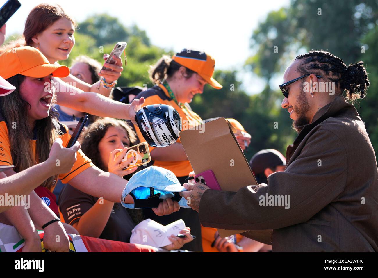 Ferrari driver Lewis Hamilton of Britain signs autographs for fans as ...