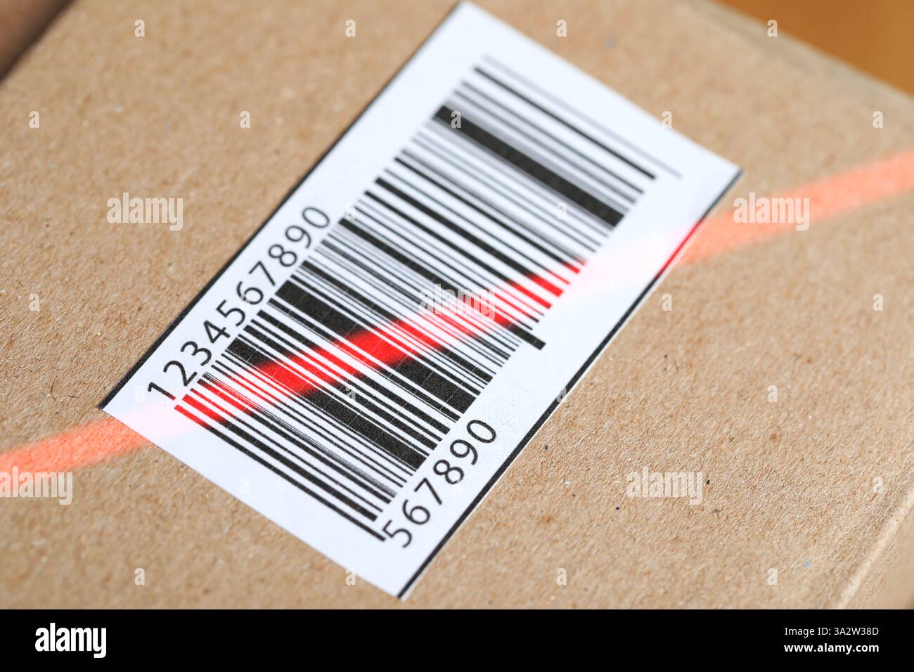 Parcel with label, closeup. Red laser light on barcode for scanning ...
