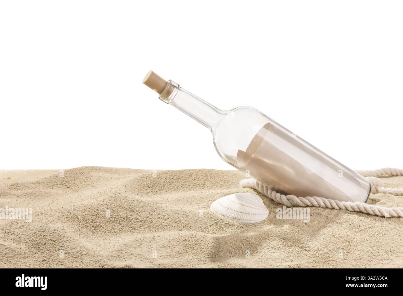 Rolled letter in corked glass bottle, rope and shell on sand against ...