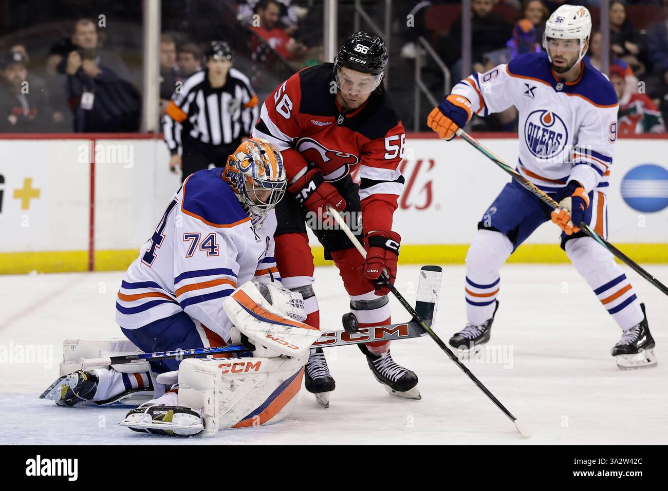 Edmonton Oilers goaltender Stuart Skinner (74) makes a save in front of New Jersey Devils left ...