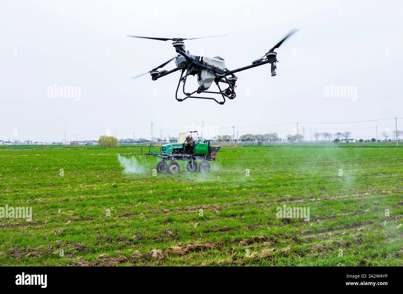 XINGHUA, CHINA - MARCH 13, 2025 - Farmers operate a plant protection ...