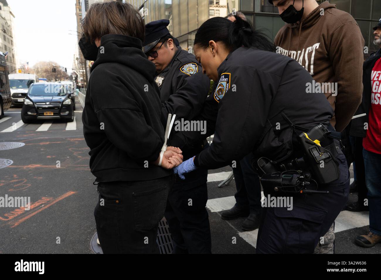 Manhattan, United States. 13th Mar, 2025. A female cop adjusts the zip ...