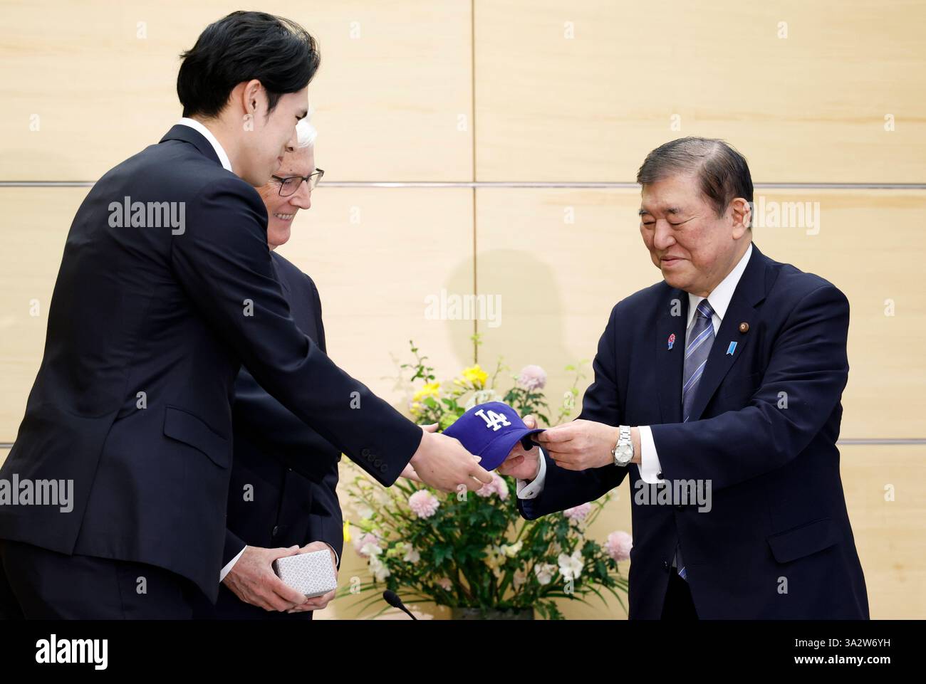 Japan's Prime Minister Shigeru Ishiba, right, receives a baseball cap ...