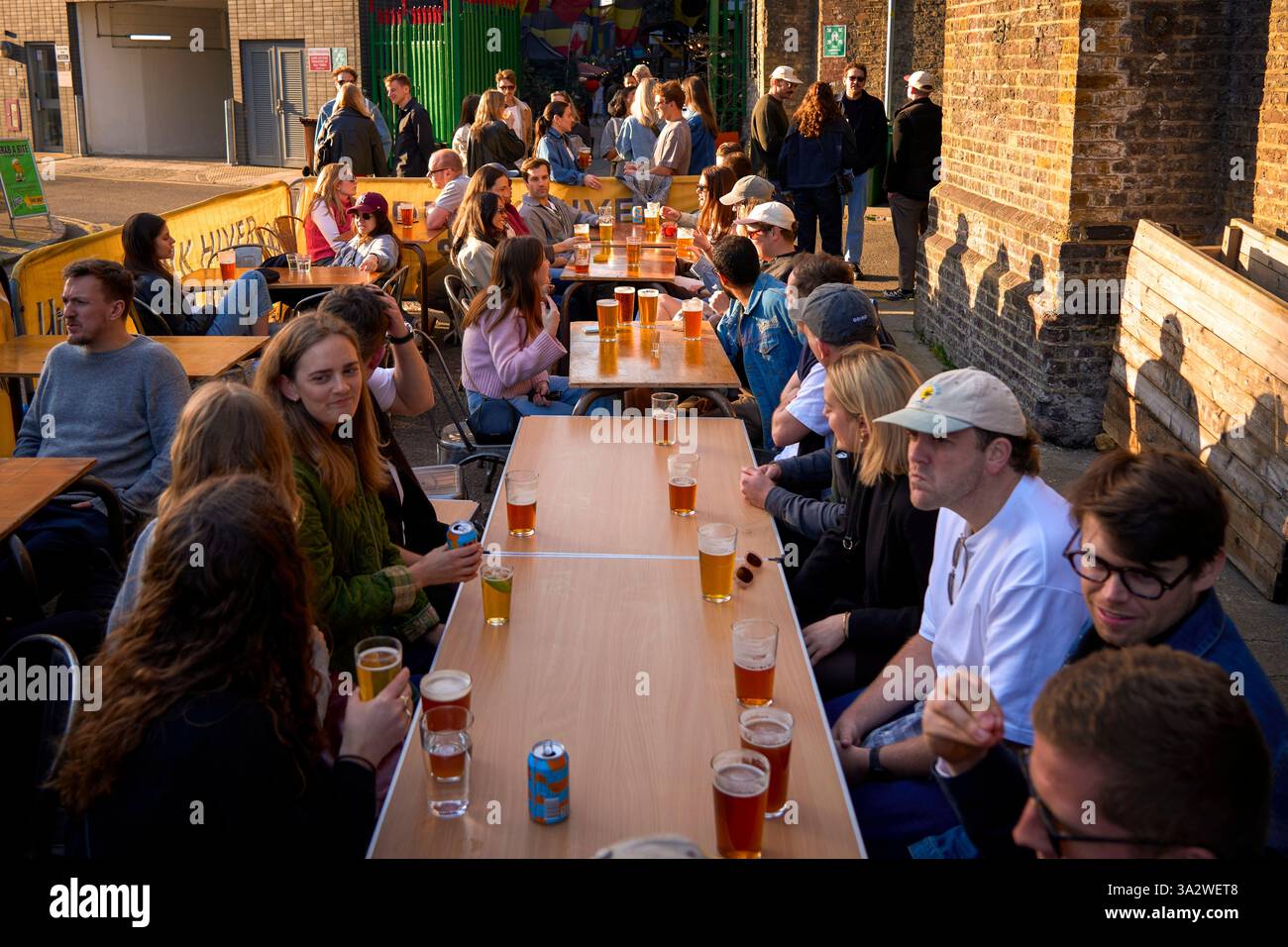 Customers take a beer outside the Hiver Beers bar and brewery on the ...