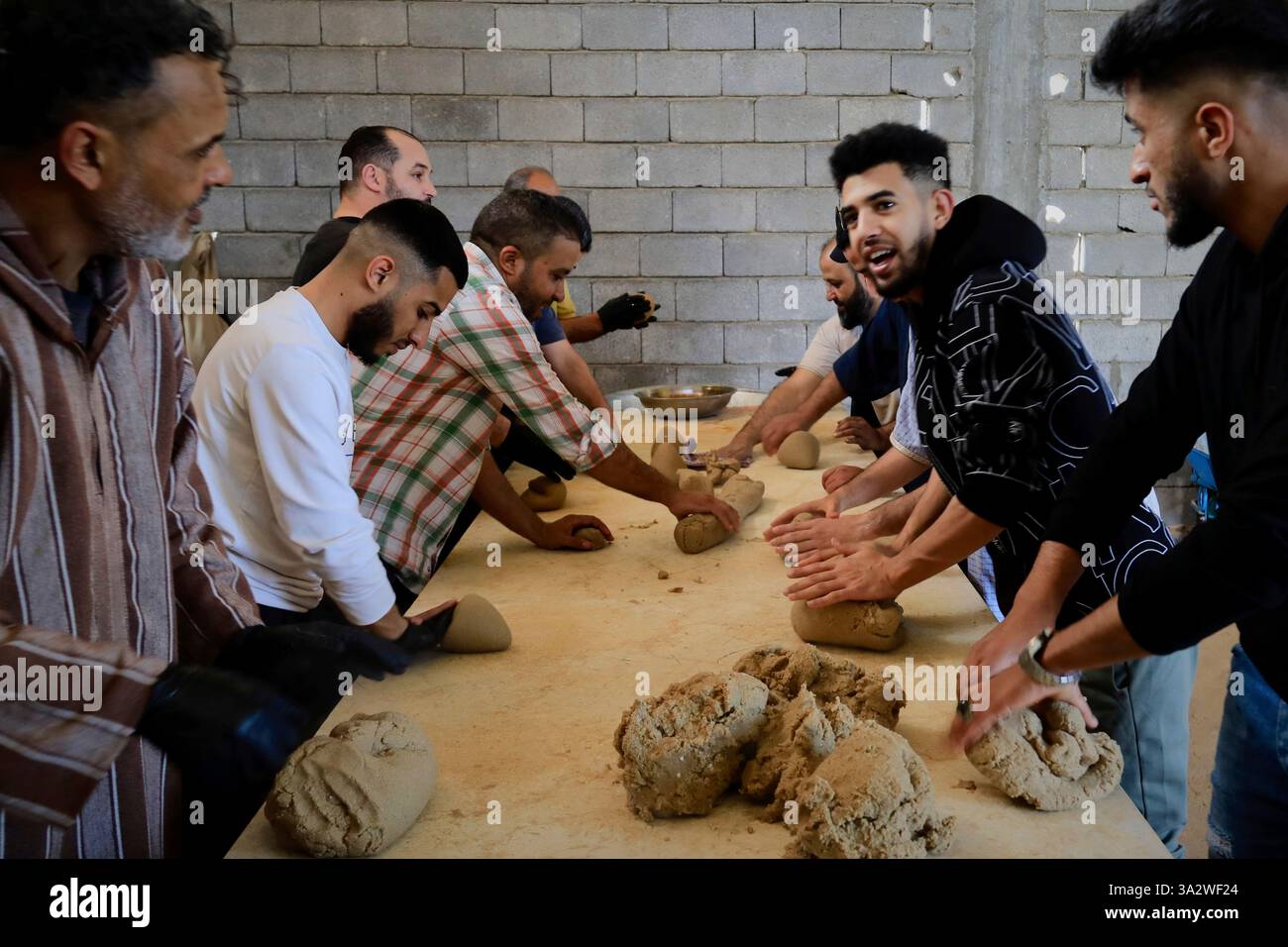 Volunteers prepare Bazin, traditional Libyan dough bread made of barley ...