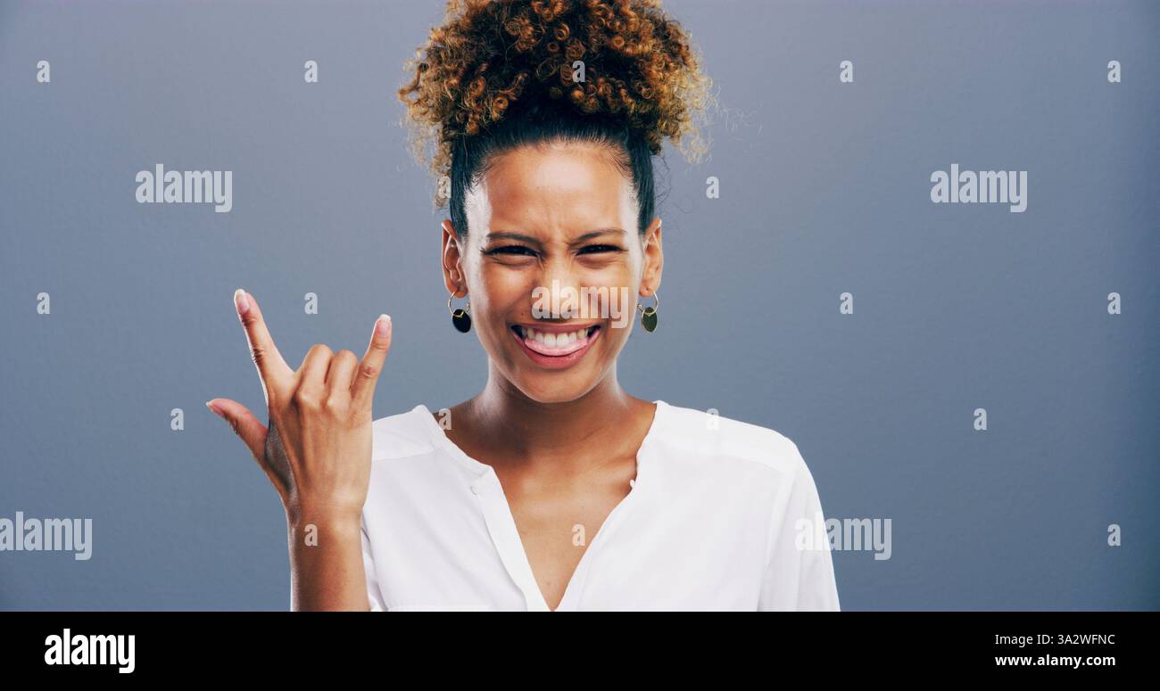 Portrait, woman and rock hand gesture in studio for music, heavy metal ...