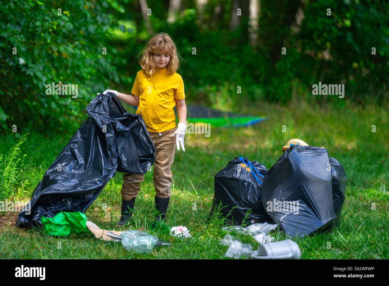 Child picking plastic trash for cleaning the nature. kid Clean up ...