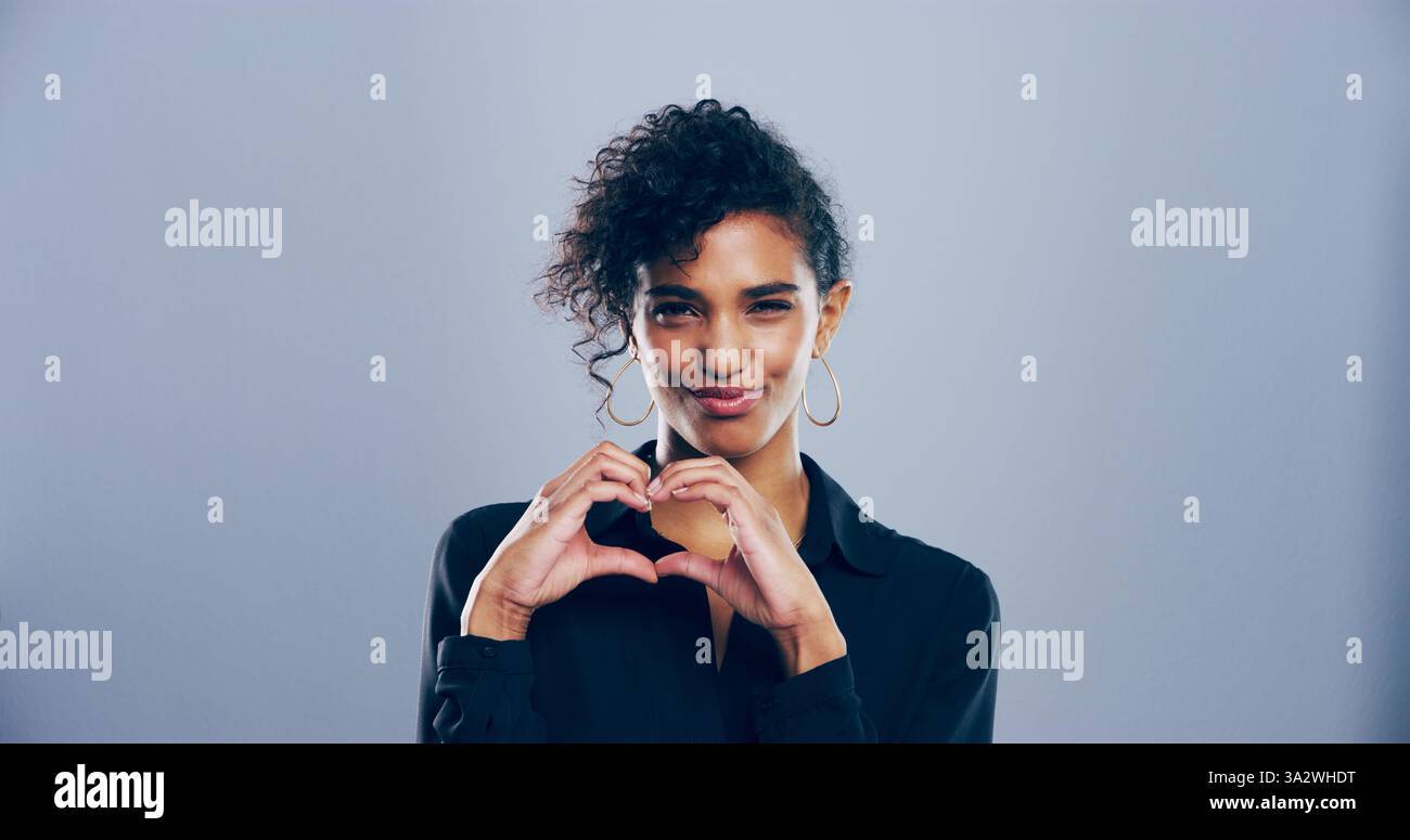 Heart hands, portrait and smile with flirty woman in studio for ...