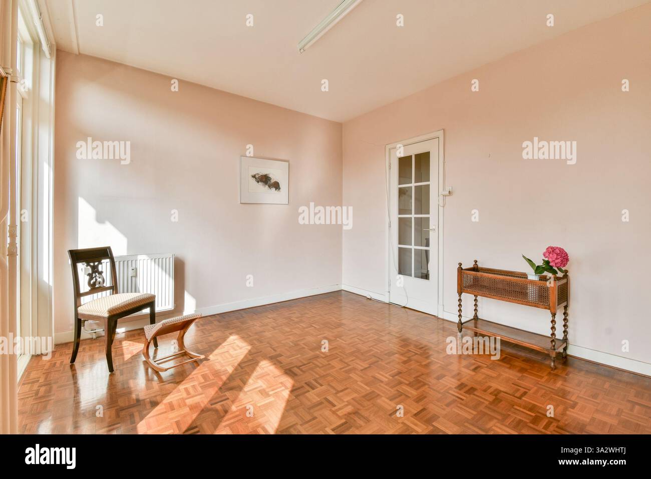 A bright, minimalist interior featuring a wooden floor, a single chair ...