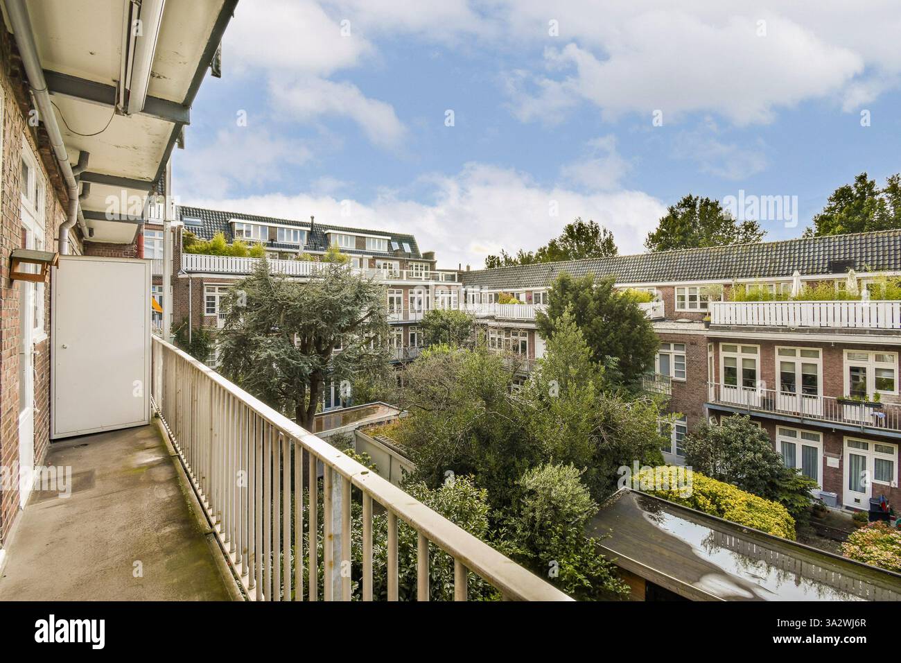 A scenic balcony view showcases green trees and beautifully arranged ...