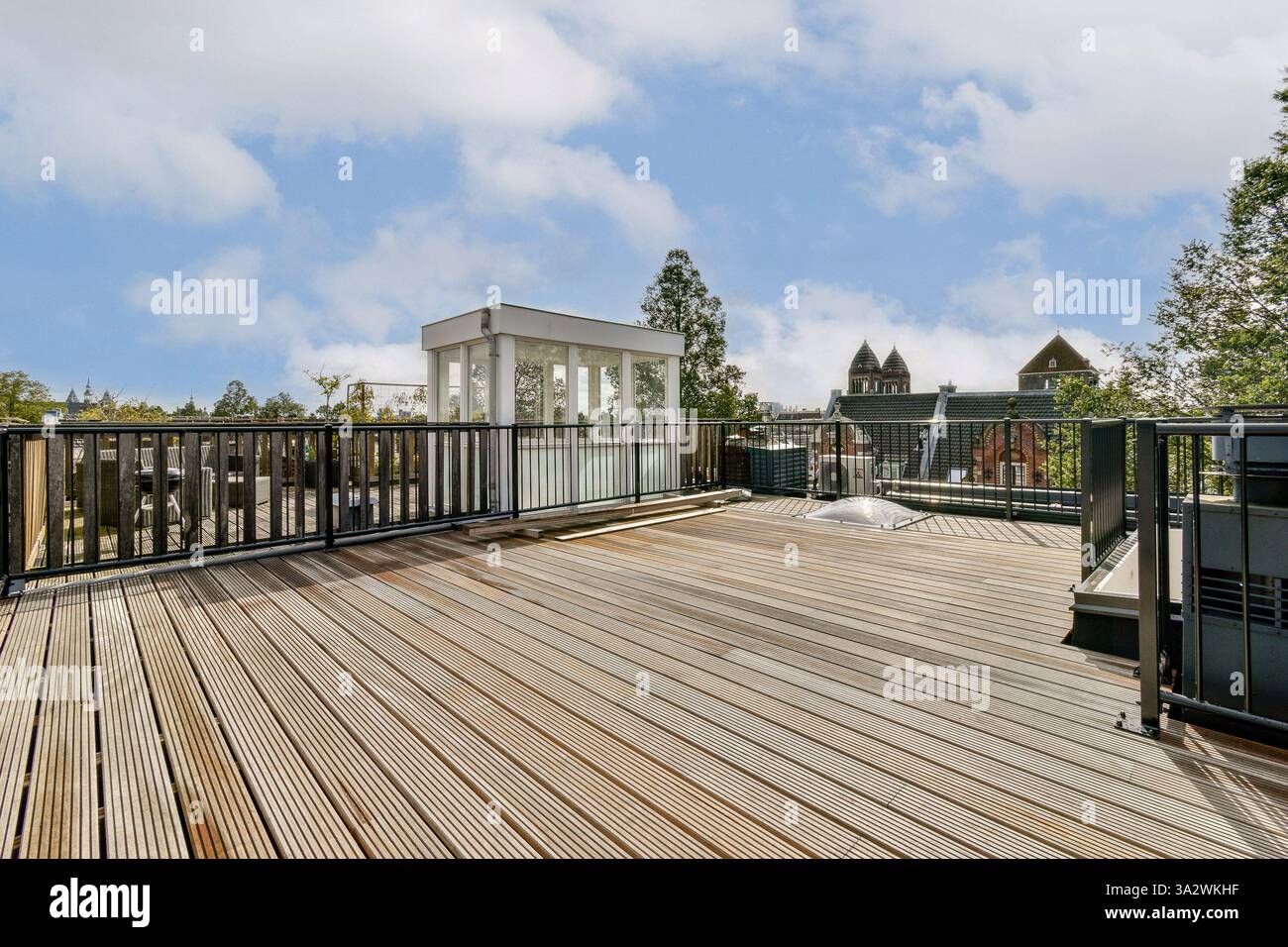 A modern rooftop terrace featuring wooden decking and a scenic urban ...