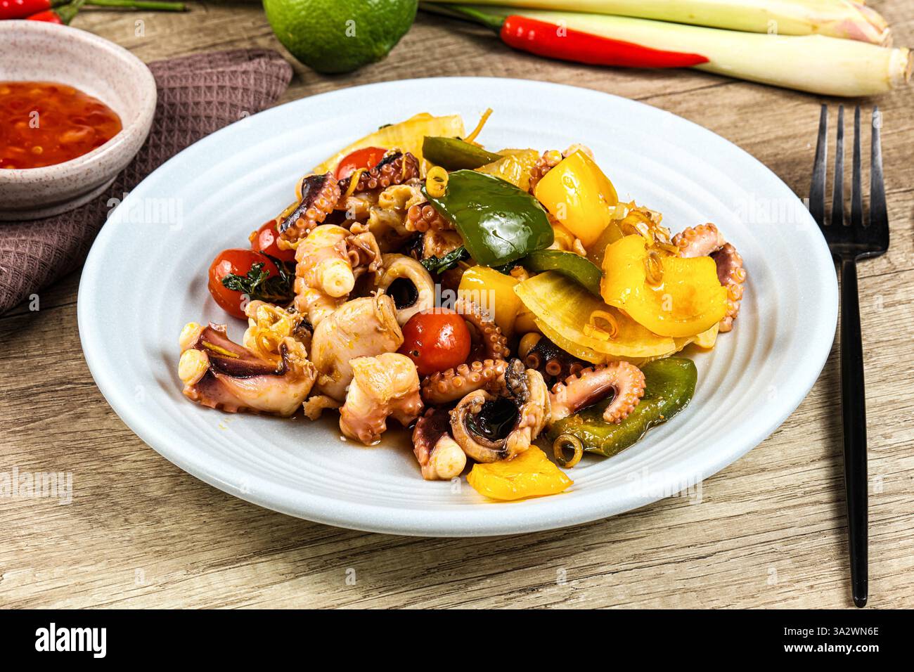 Roasted octopus with vegetables, spices and oil Stock Photo - Alamy