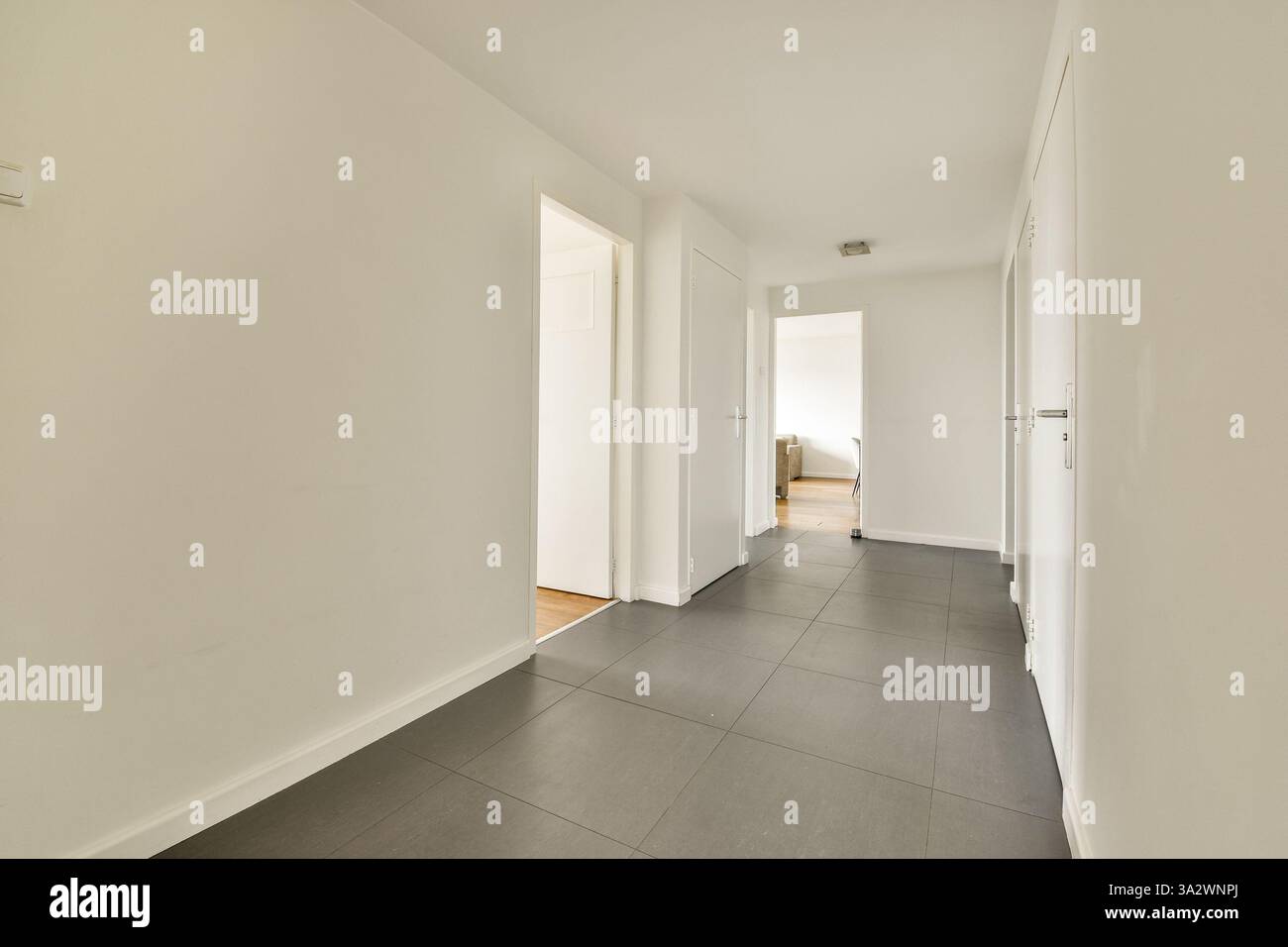 A spacious hallway featuring a minimalist design with neutral colors ...