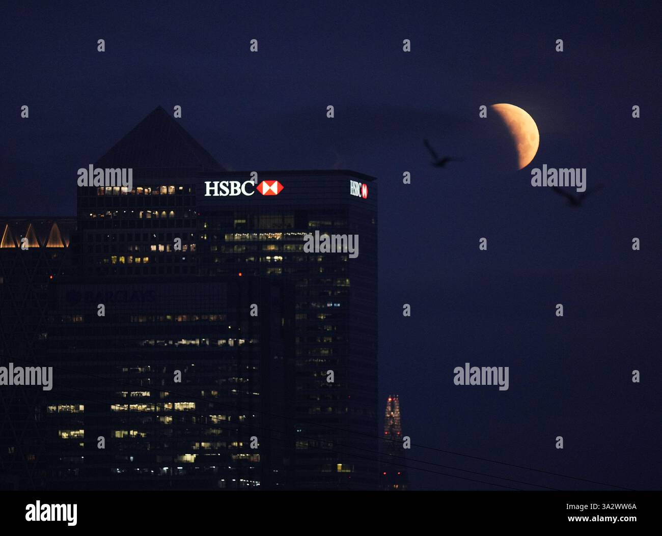 A lunar eclipse is visible above Canary Wharf in London as the full ...