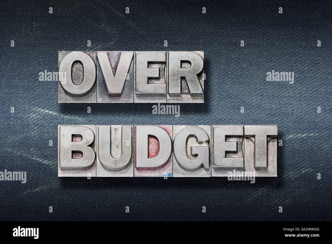 over budget phrase made from metallic letterpress on dark jeans ...