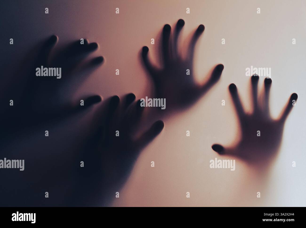 Silhouettes of multiple hands are depicted pressing against a frosted ...
