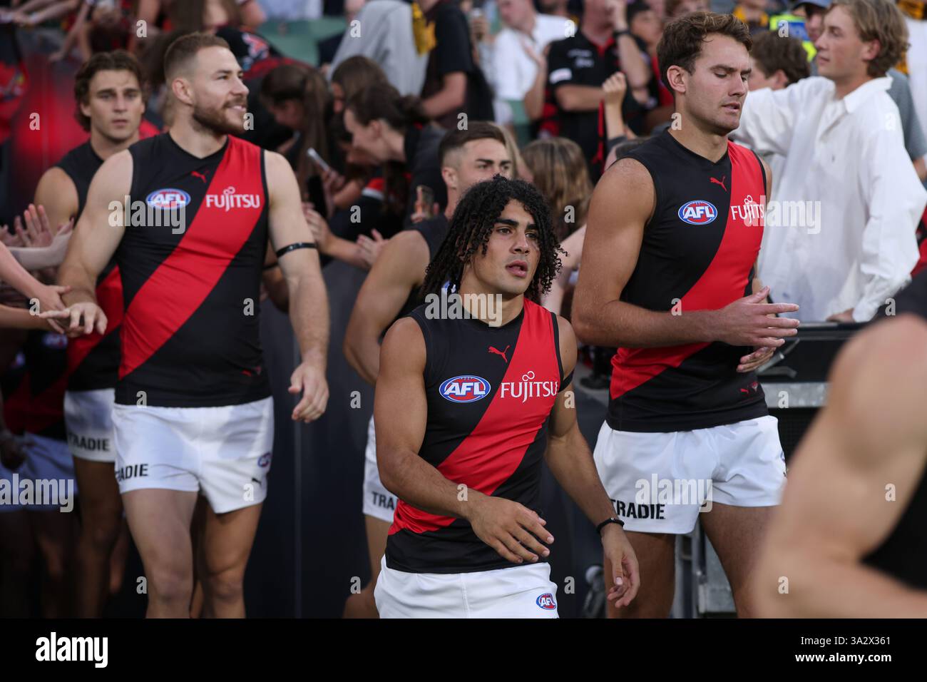 Isaac Kako of the Bombers (centre) takes to the field with teammates ...