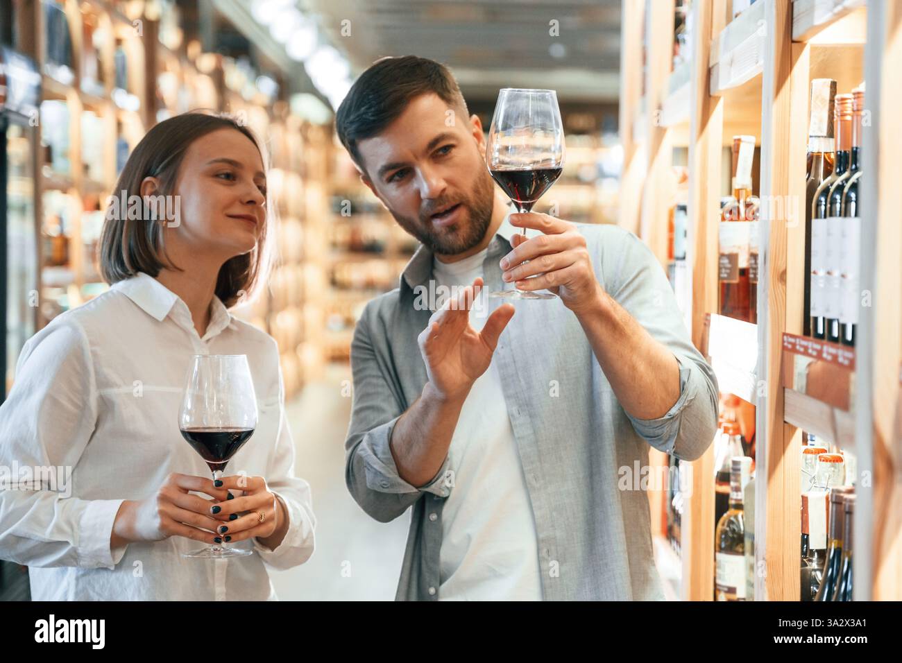 Glasses with drink. Take a sample. Man and woman are choosing wine in ...