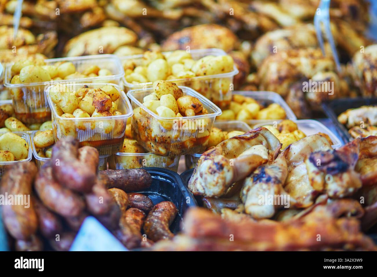 Baked potatoes and fried chicken, pork and suasages on a farmer market ...
