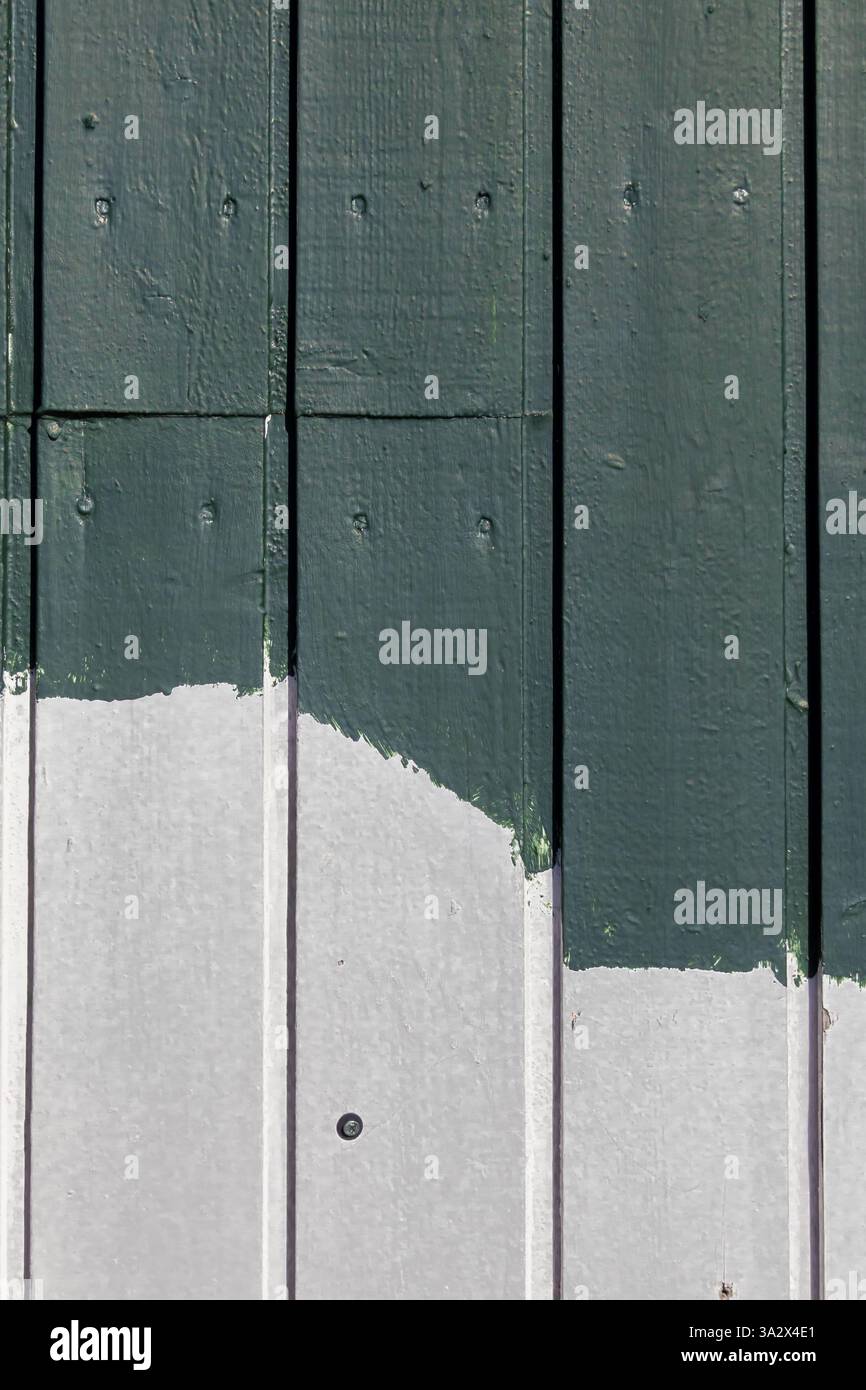 A close-up of painted wooden planks on a building facade, with uneven ...