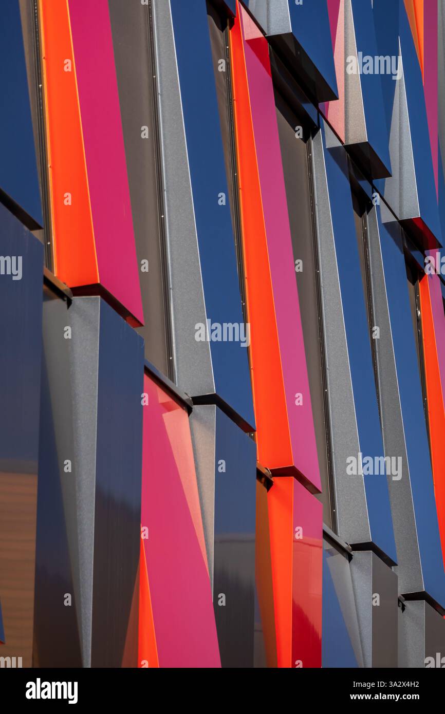 A modern building facade composed of red and dark blue metal rectangles ...
