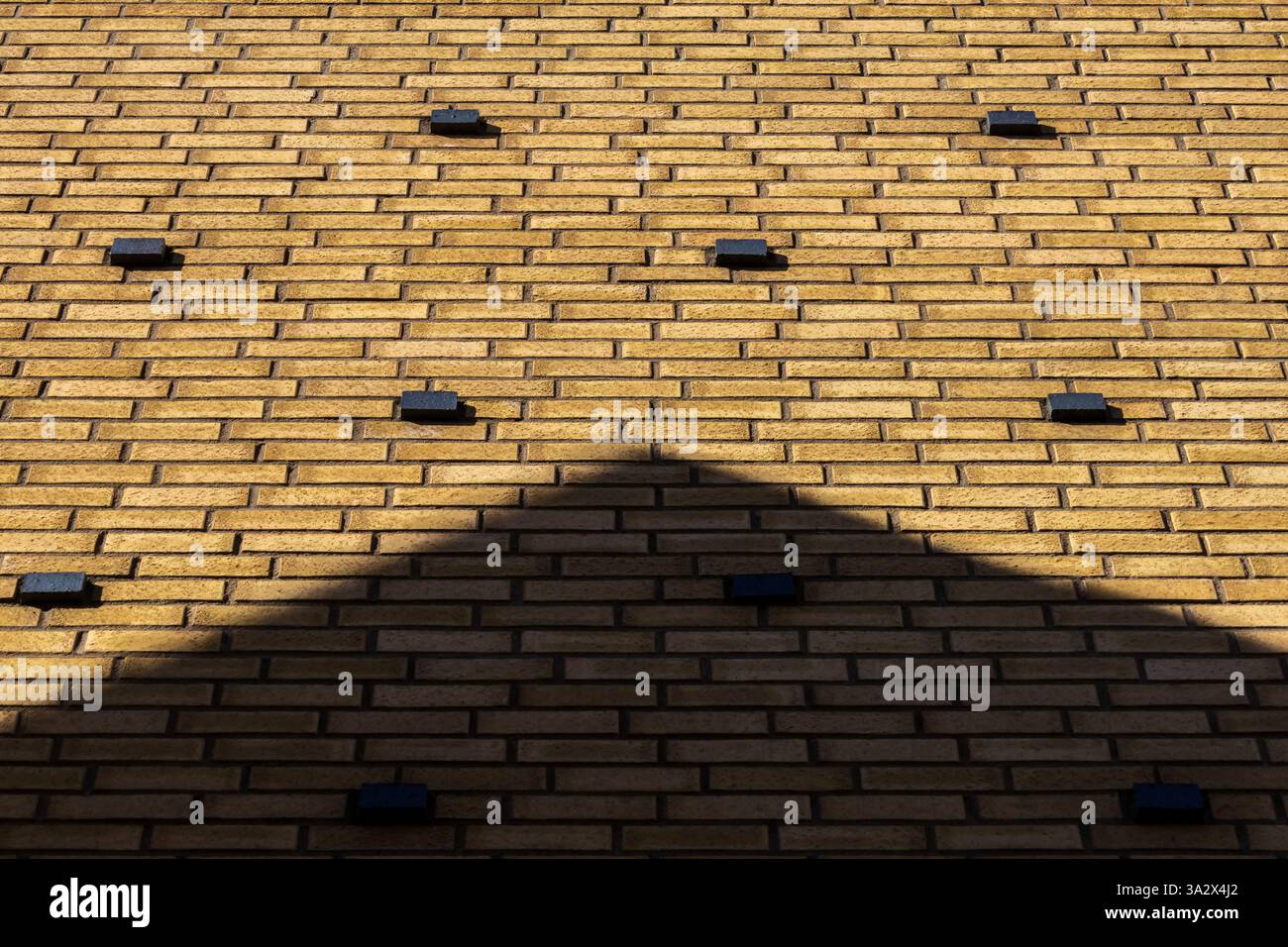 A yellow brick building facade features raised rectangular black iron ...