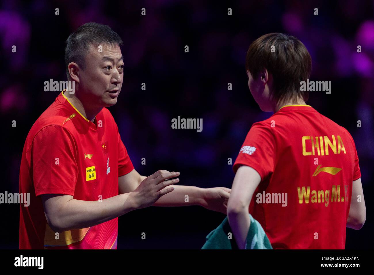 Chongqing, China. 14th Mar, 2025. Coach Ma Lin (L) instructs Wang Manyu ...