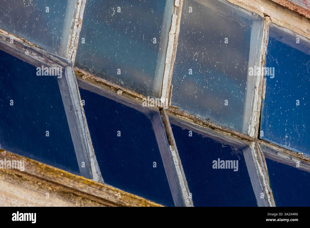 An old multi-pane window with small square glass panels, set in a ...