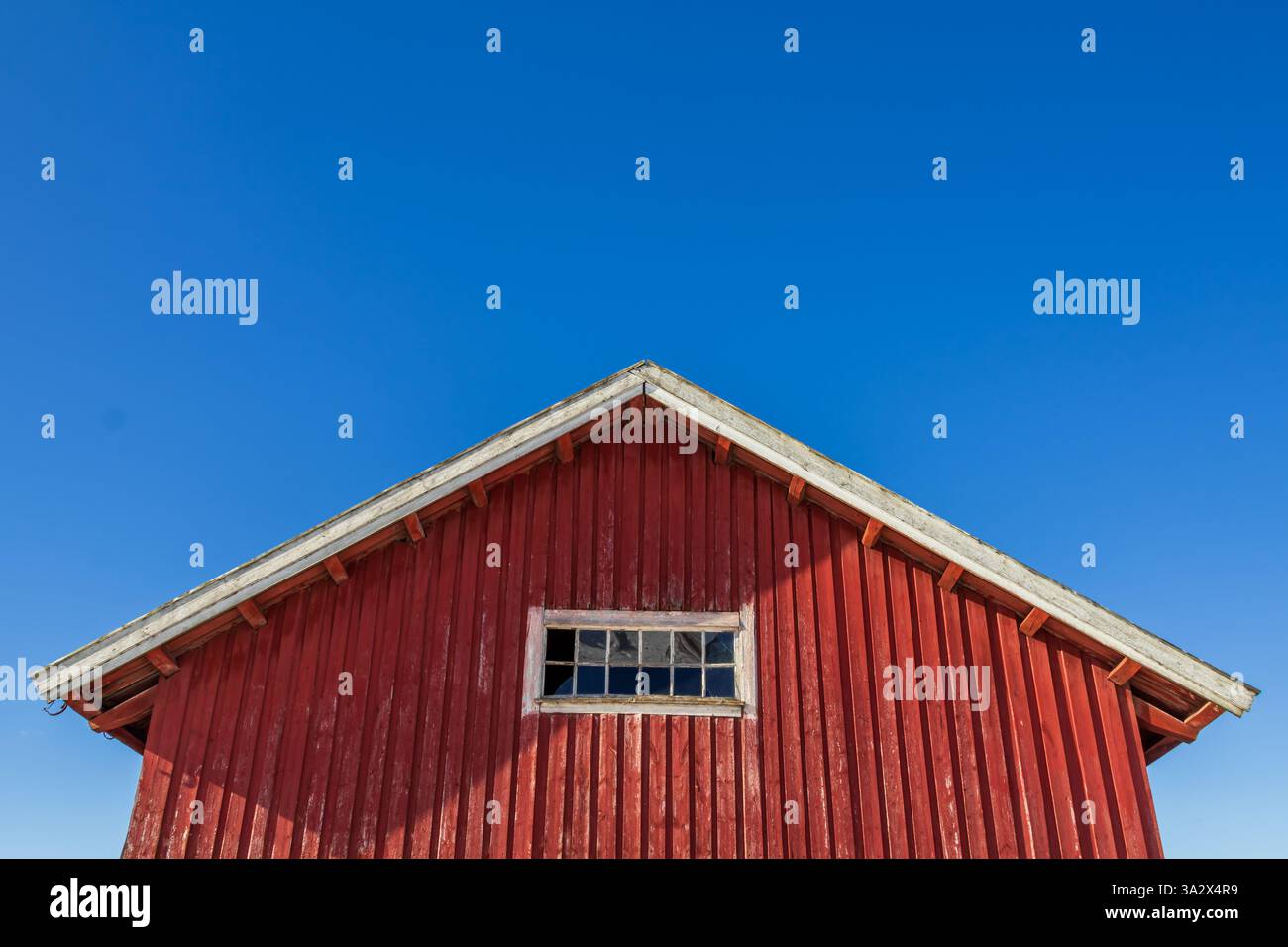 The upper section of an old barn with a central window sits perfectly ...