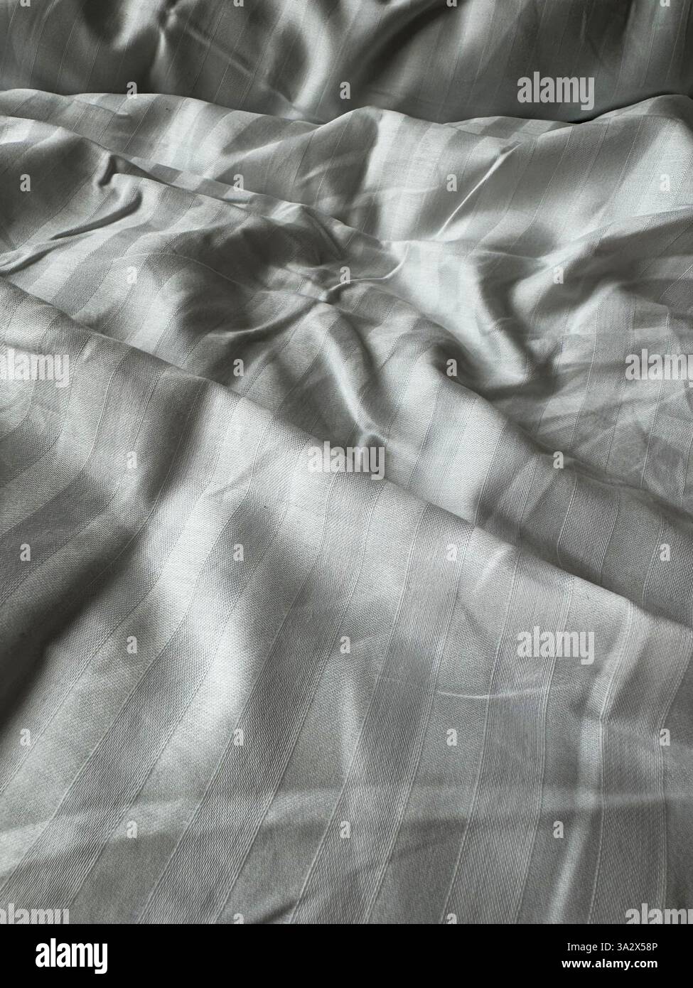 This close-up displays a soft, wrinkled fabric with subtle stripes ...