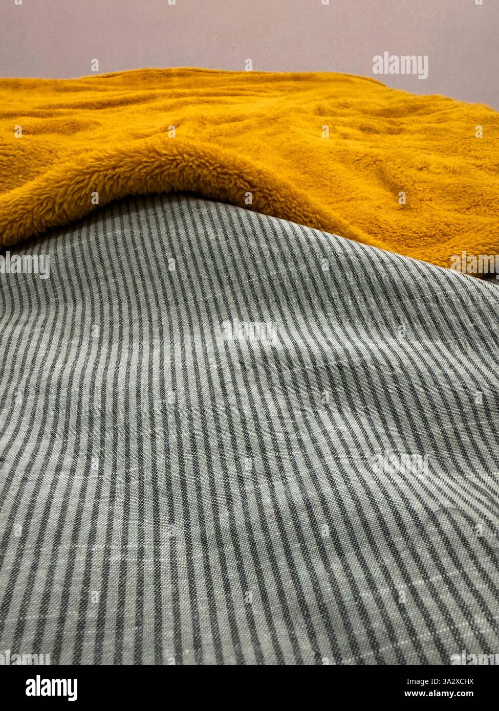 Cozy layers of texture featuring a yellow blanket and striped fabric on ...