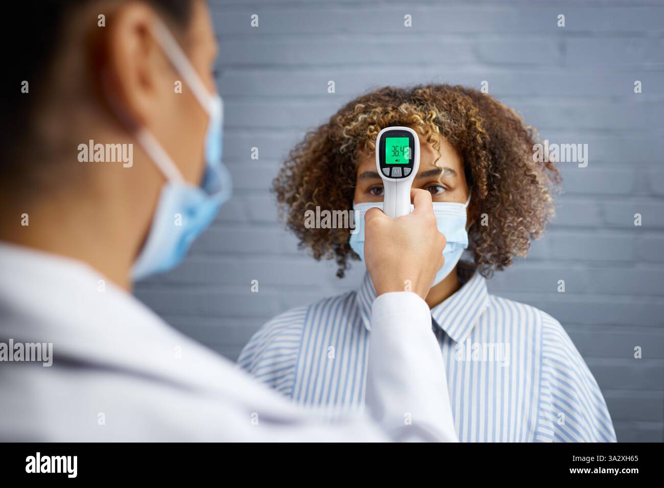 Healthcare Worker Using Infrared Thermometer on Patient to Check Body ...