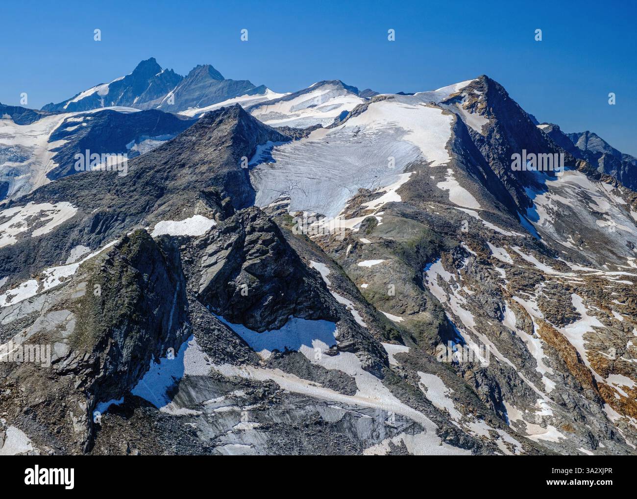 Kitzsteinhorn Glacier with rugged peaks under a clear blue sky. Aerial ...