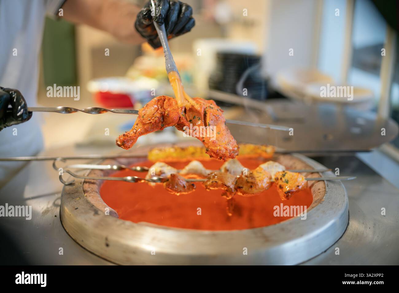 Professional indian chef brushing tandoori marinade on chicken tikka ...