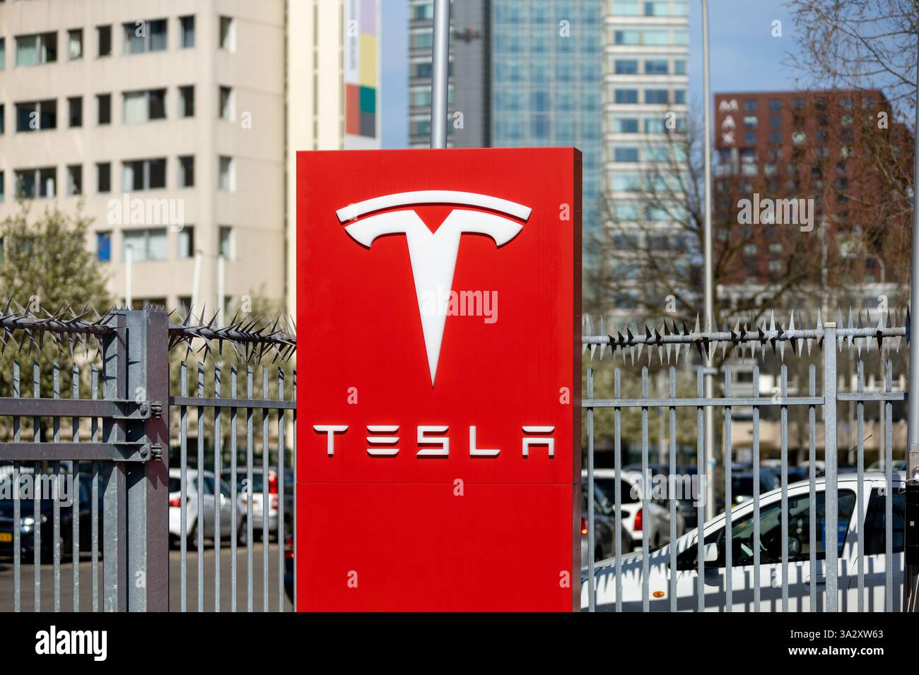 Tesla logo sign on a red column surrounded with a fence Stock Photo - Alamy