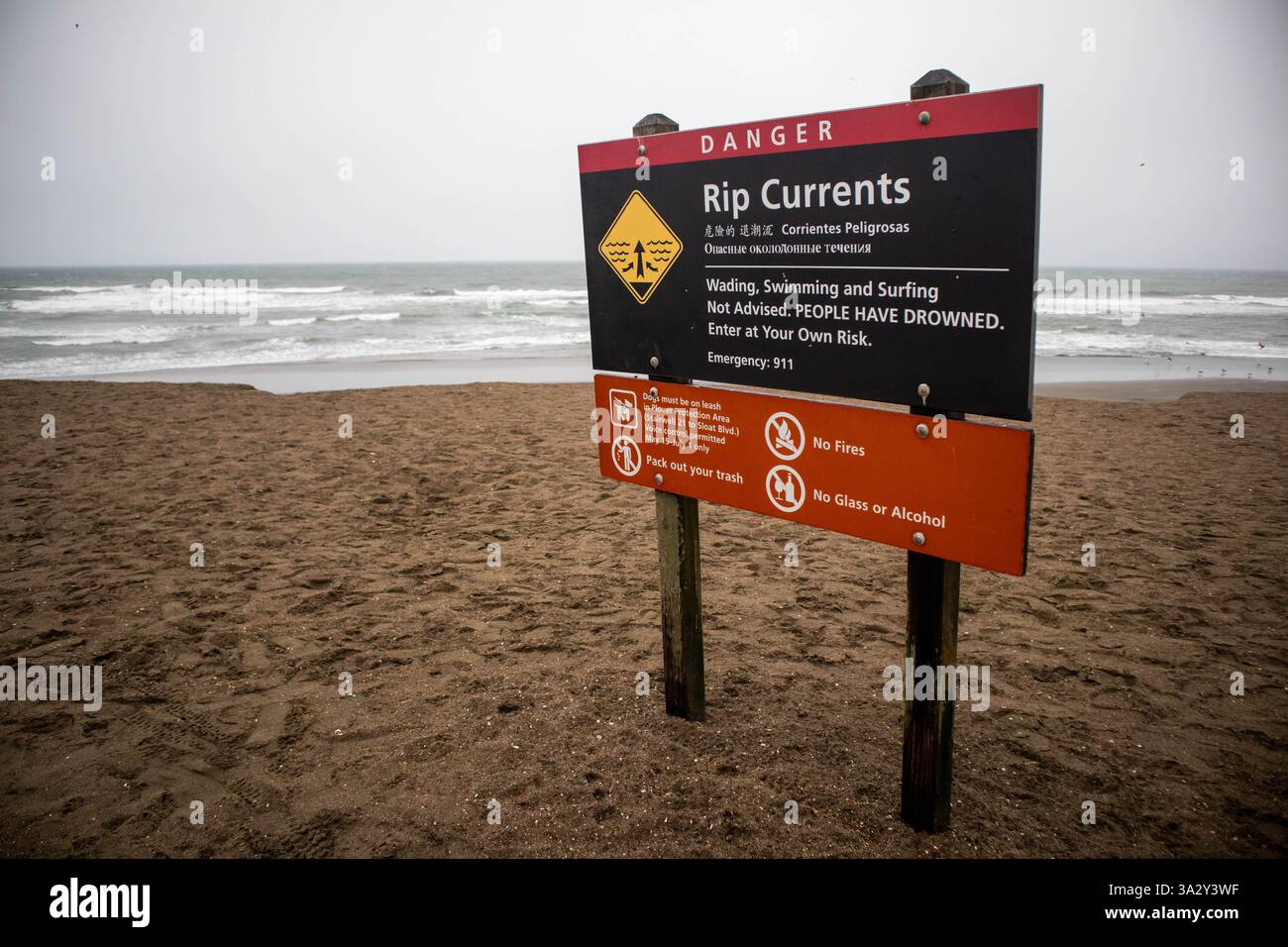 Rip current warning sign on Ocean Beach, ocean waves in background ...