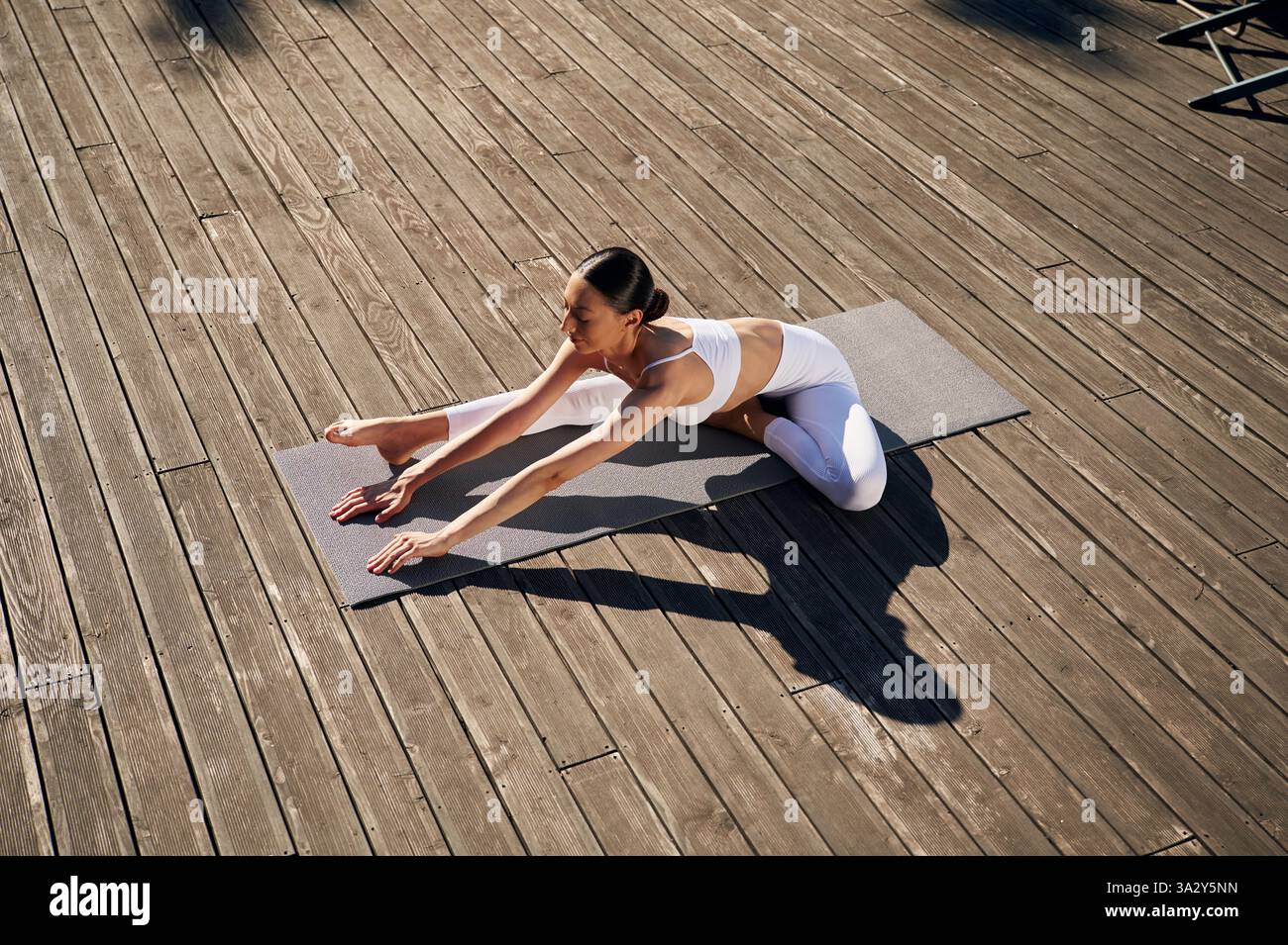 Flexible body type and exercises. Young woman in fitness clothes is ...