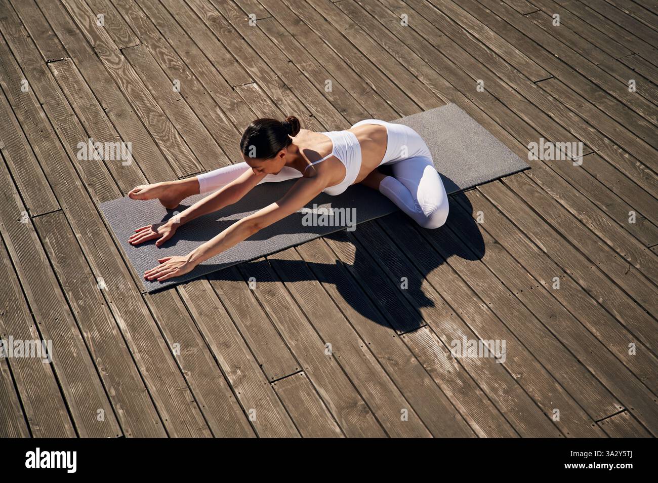 Flexible body type and exercises. Young woman in fitness clothes is ...