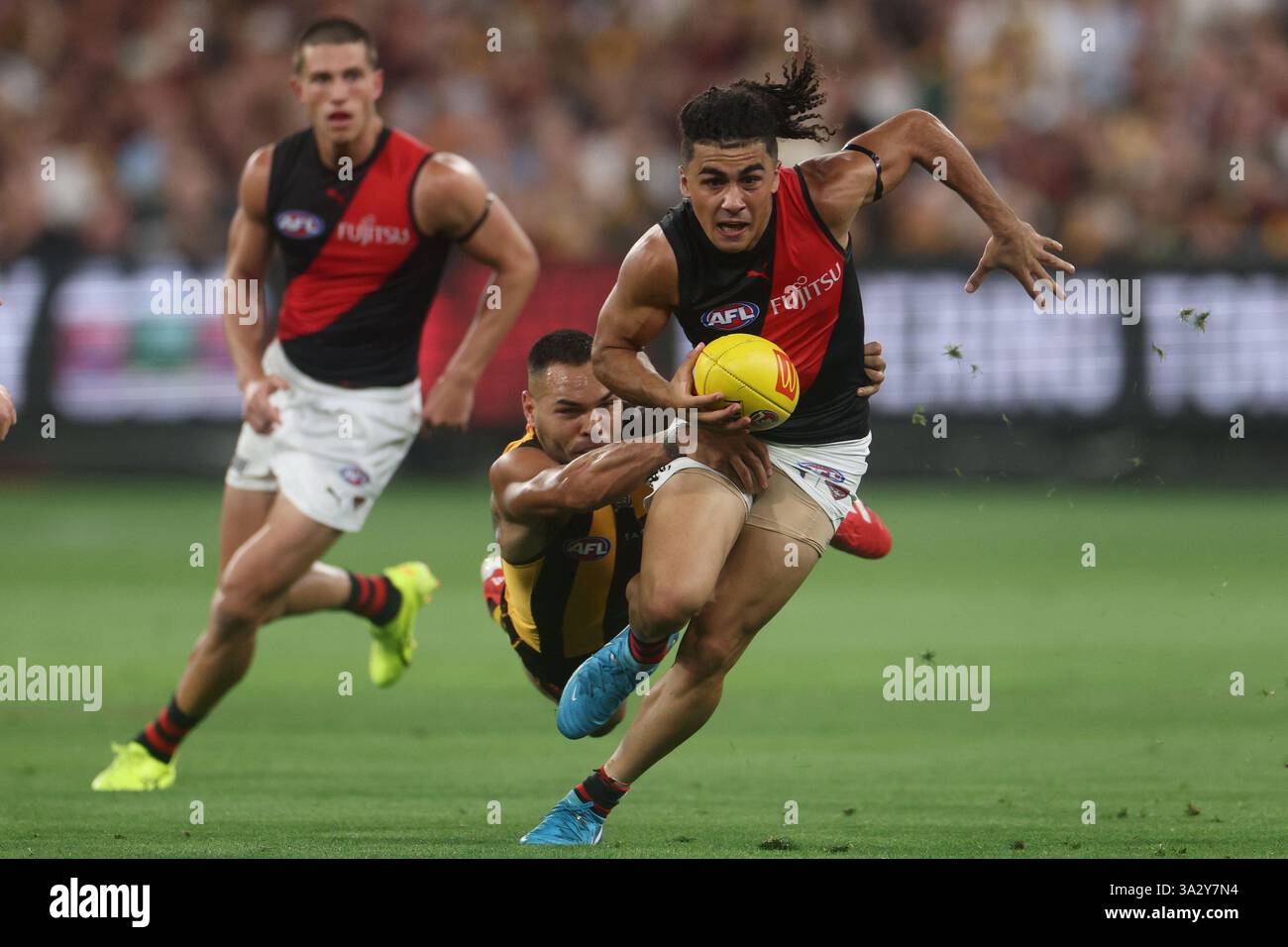 Isaac Kako of the Bombers breaks a tackle attempt from Jarman Impey of ...