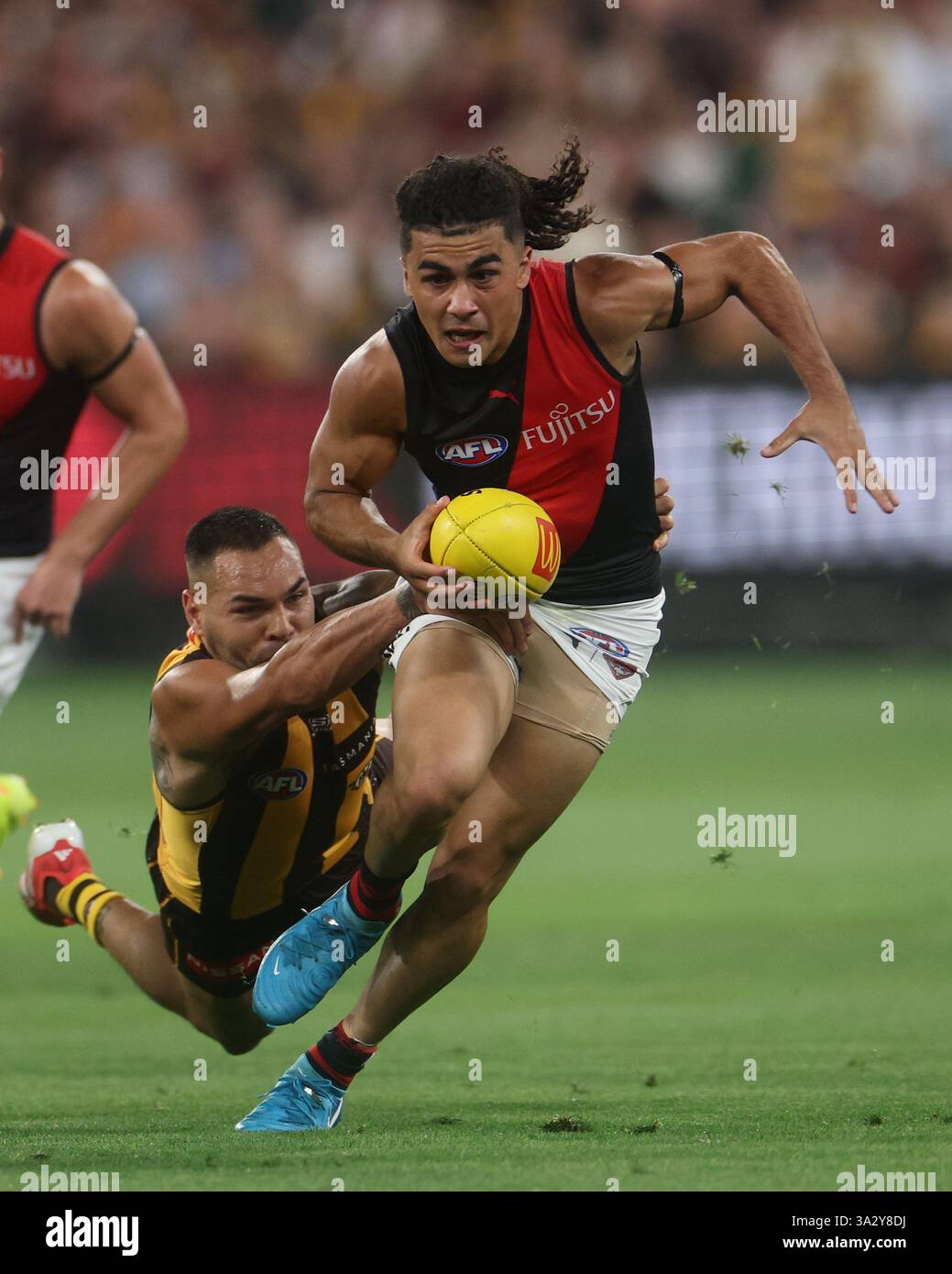 Isaac Kako of the Bombers breaks a tackle attempt from Jarman Impey of ...
