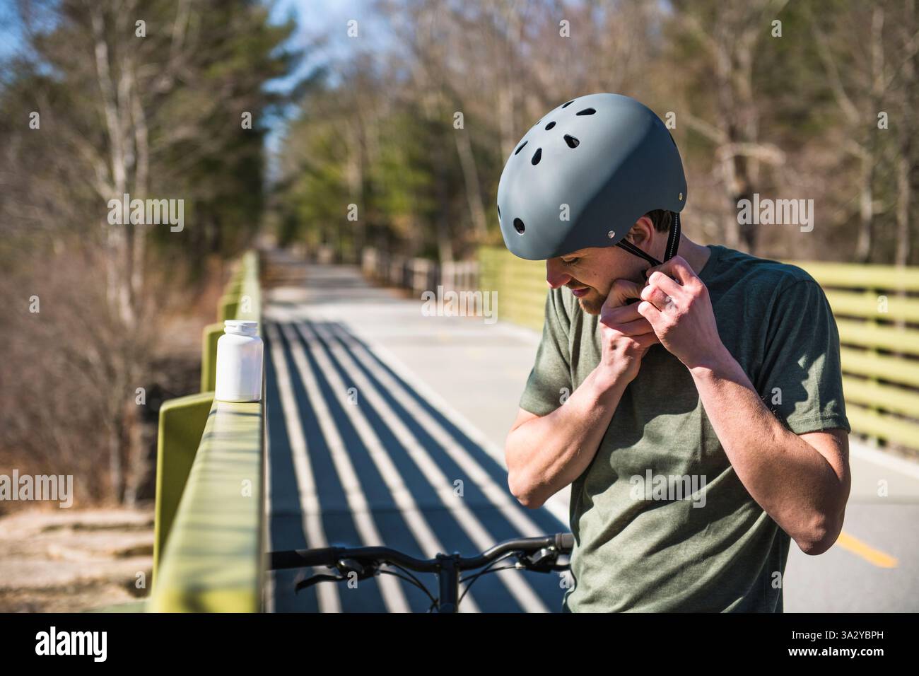 Man buckling helmet with dietary supplements on bike ride Stock Photo ...