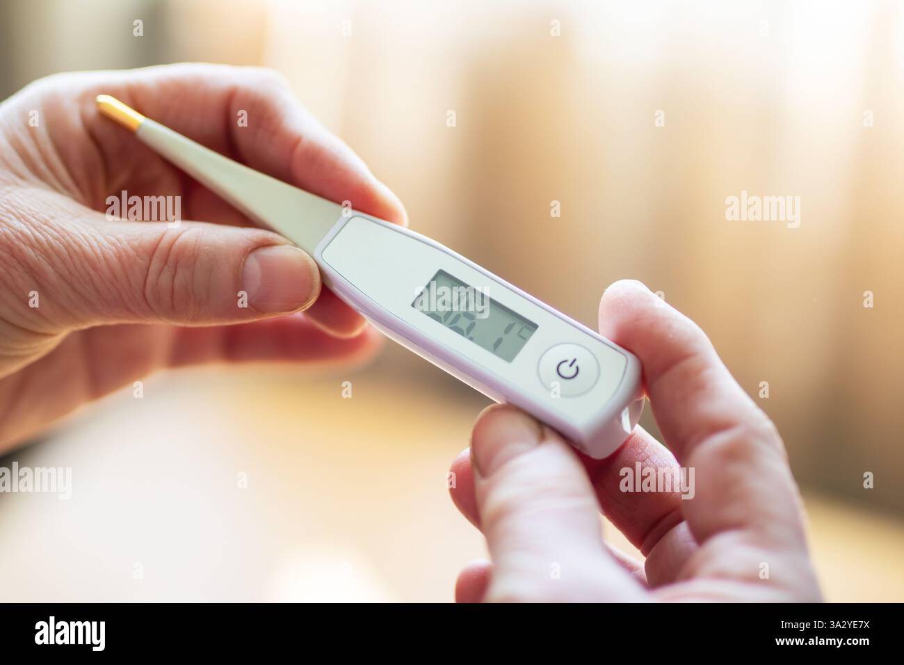 A person is holding a thermometer securely in their hand, and upon ...