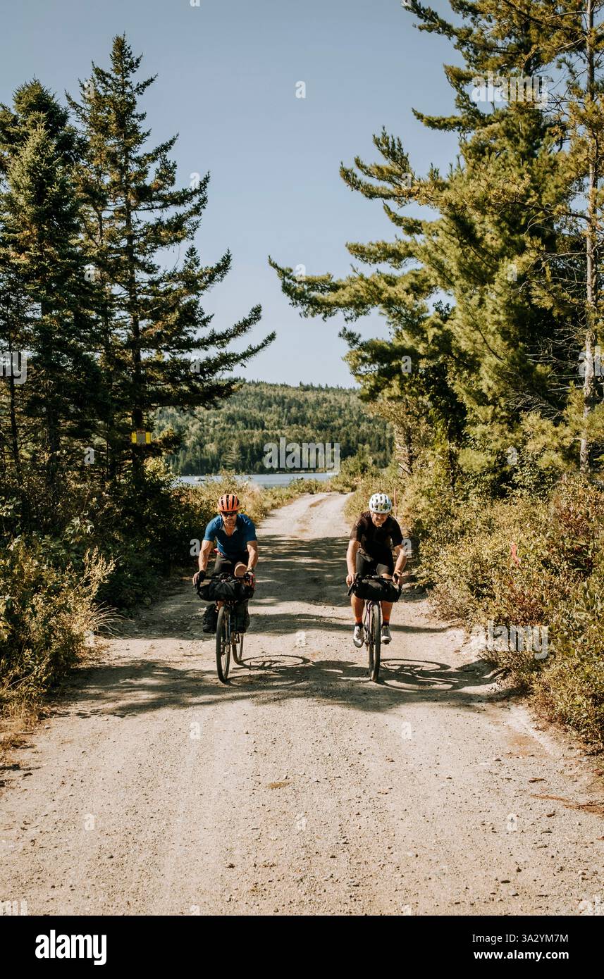 two men ride bikes while cycle touring 100 mile wilderness, Maine Stock ...