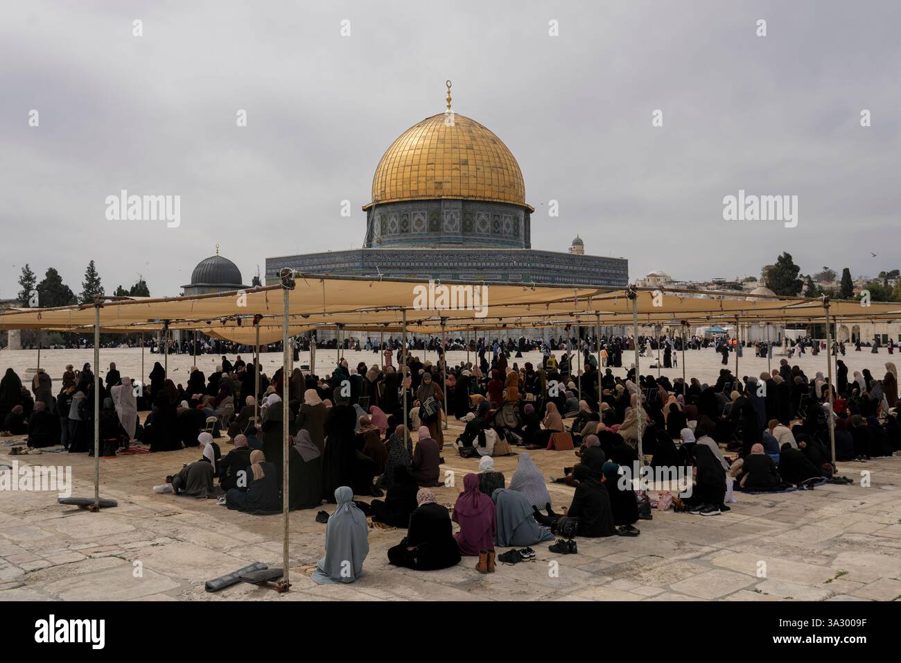Palestinian women sit under the shade before Friday prayers at the Al ...