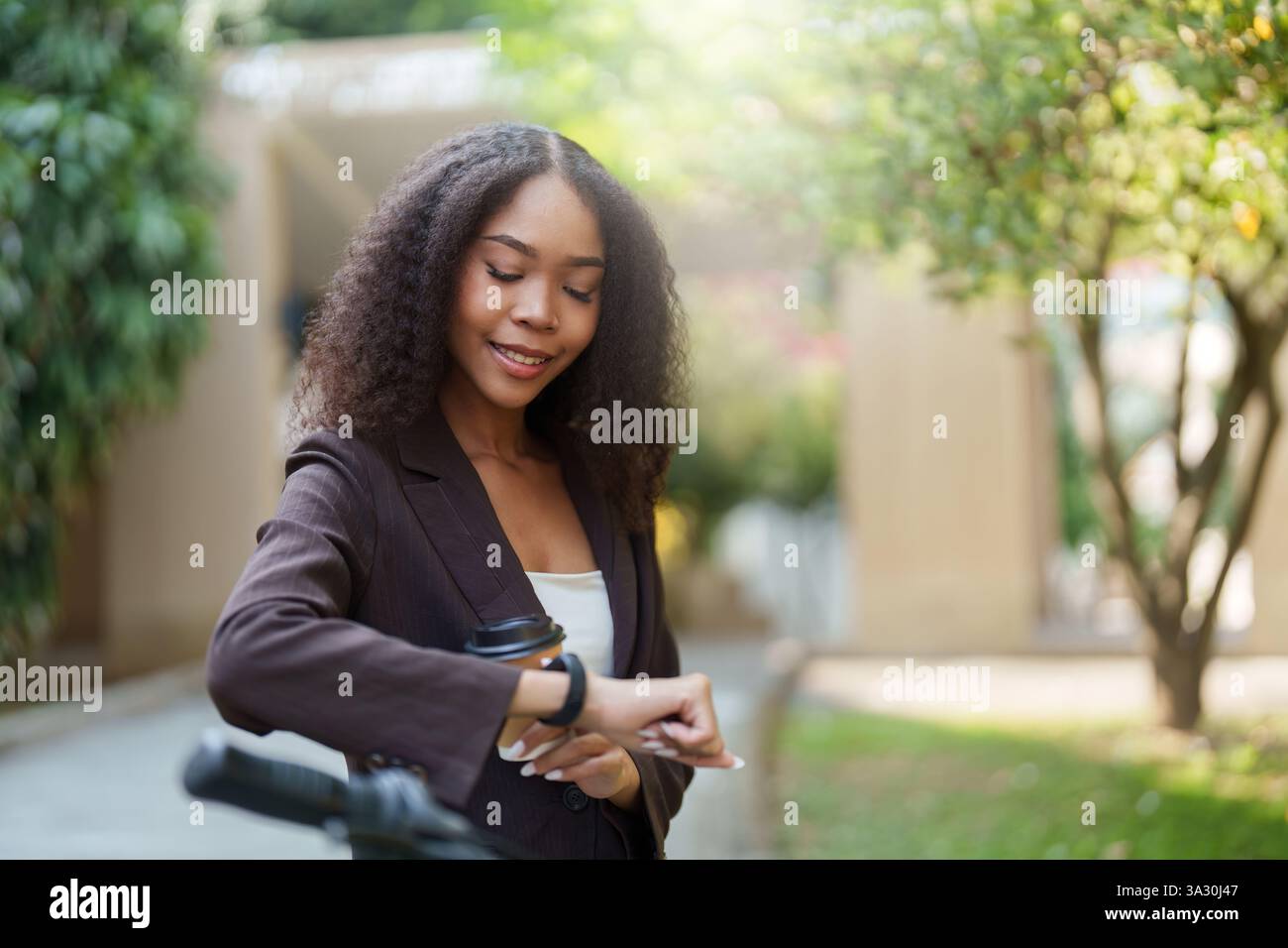 Time Management and Urban Living. A young woman checks her watch while ...